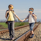 Happy brother and sister walking on the railway at the day time. Stock ...