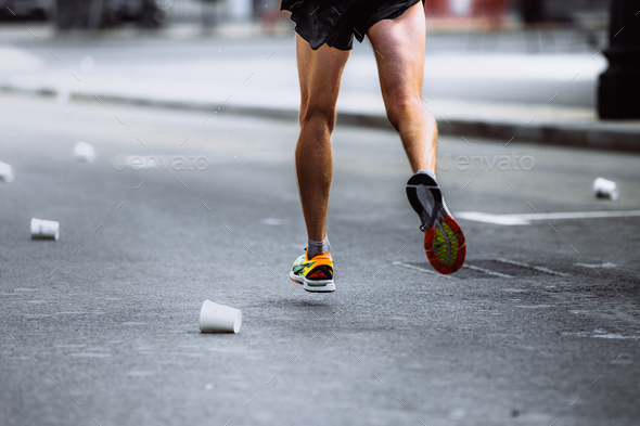 Male Athlete Running on Asphalt Road Stock Photo by realsportsphotos