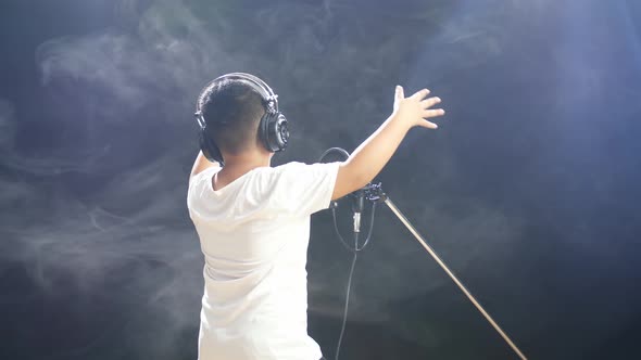 Back View Of A Young Boy With Headphone Rapping On The White Smoke ...
