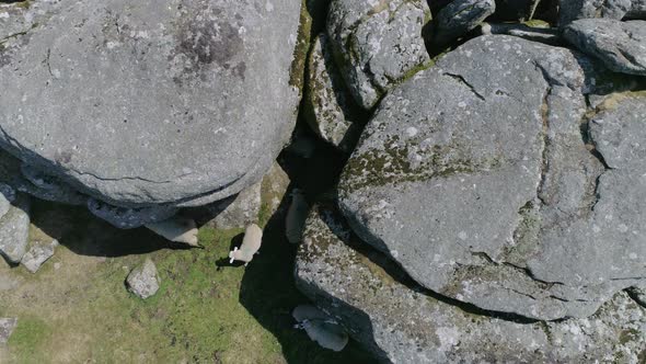 Birdseye aerial shot tracking backwards slowly over a rocky tor, with ...