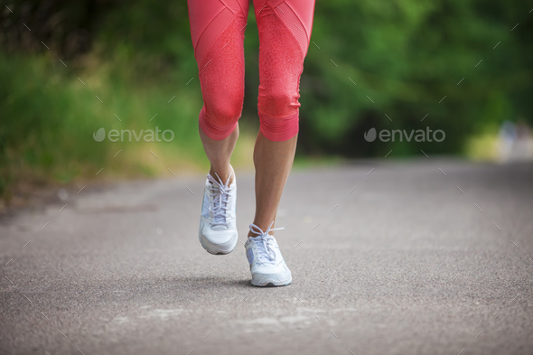 Cropped view of woman athlete running on pathway in park Stock Photo by ...