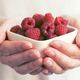 Crockery with raspberries in woman hands Stock Photo by stevanovicigor