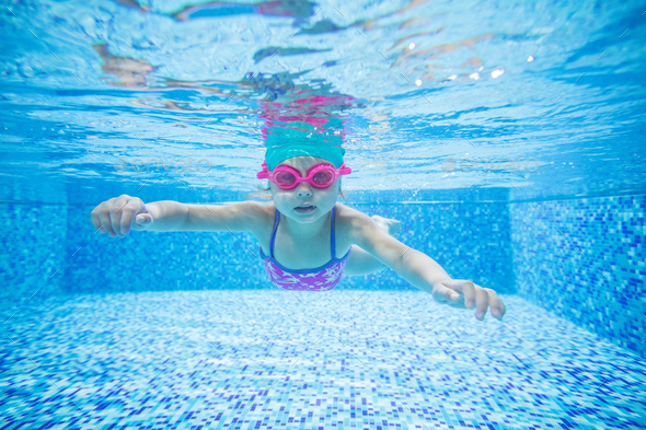 Little girl diving in swimming pool Stock Photo by photobac | PhotoDune