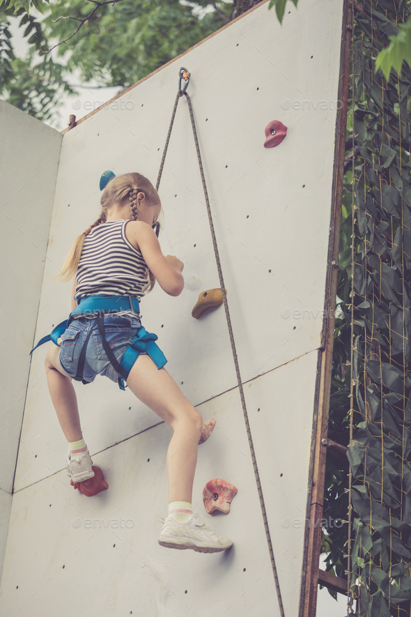 little girl climbing a rock wall outdoor. Stock Photo by altanaka ...