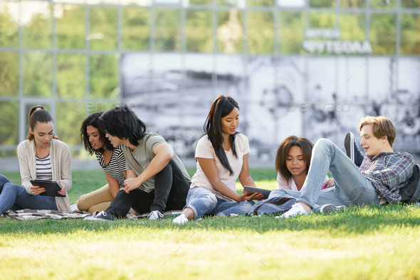 Concentrated students studying outdoors. Stock Photo by vadymvdrobot