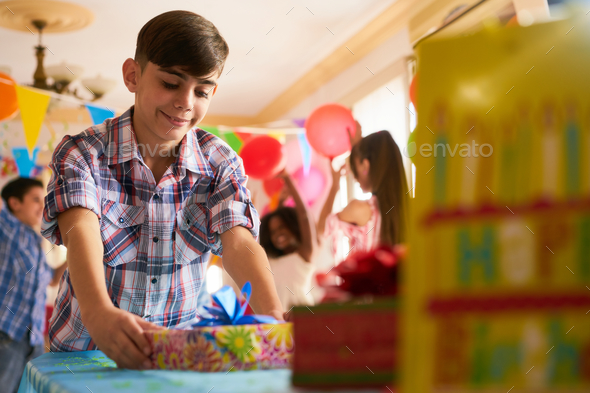 Child Putting Present On Table During Birthday Party At Home Stock ...