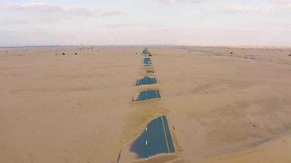 Aerial view of half desert road or street with sand dune in Dubai City ...