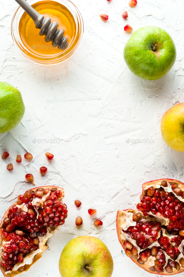 Rosh Hashanah frame of grains of pomegranate, honey and apples on a ...