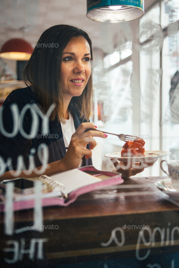 Smiling beautiful woman eating cake Stock Photo by Click_and_Photo