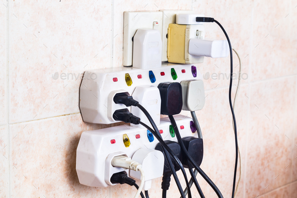 Multiple electricity plugs on adapter risk overloading and dange Stock ...