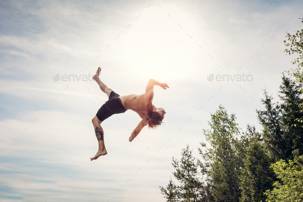 Young man doing a backflip in the air. Stock Photo by photocreo | PhotoDune