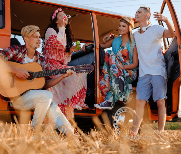 Hippie friends with guitar on a road trip Stock Photo by Nejron | PhotoDune