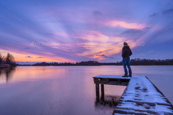 Man Looking at the Sunset From a Pier Stock Photo by CreativeNature_nl