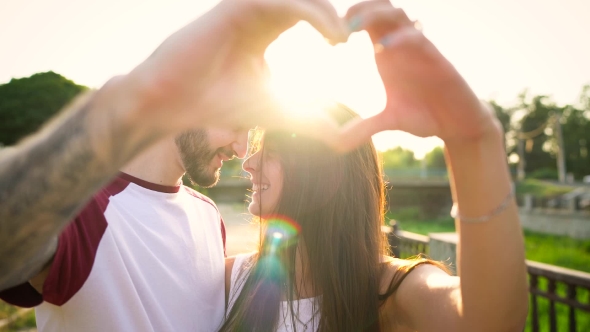 Young Couple in Love Making Heart Symbol with Their Hands at Sunset ...