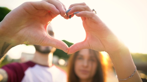 Young Couple in Love Making Heart Symbol with Their Hands at Sunset ...