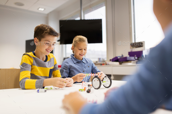 happy children building robots at robotics school Stock Photo by dolgachov
