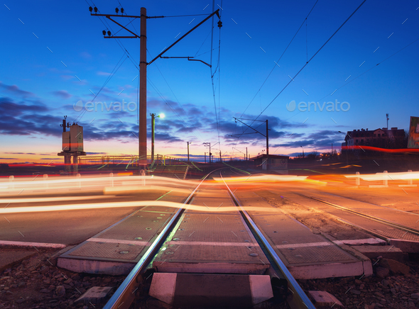 Railroad crossing with car lights in motion at night Stock Photo by den ...