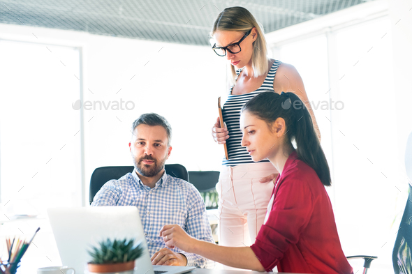 Three business people in the office talking together. Stock Photo by ...