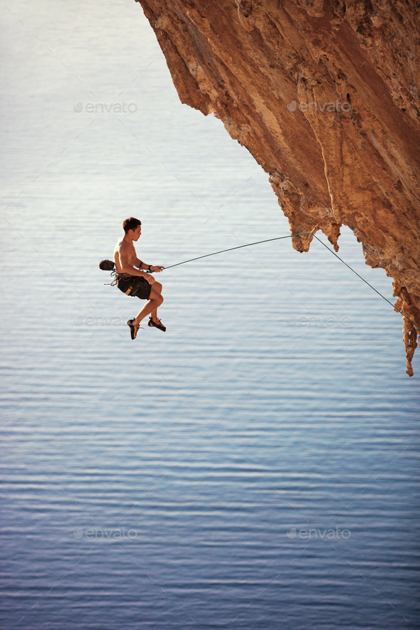 Rock climber falling of a cliff while lead climbing Stock Photo by photobac