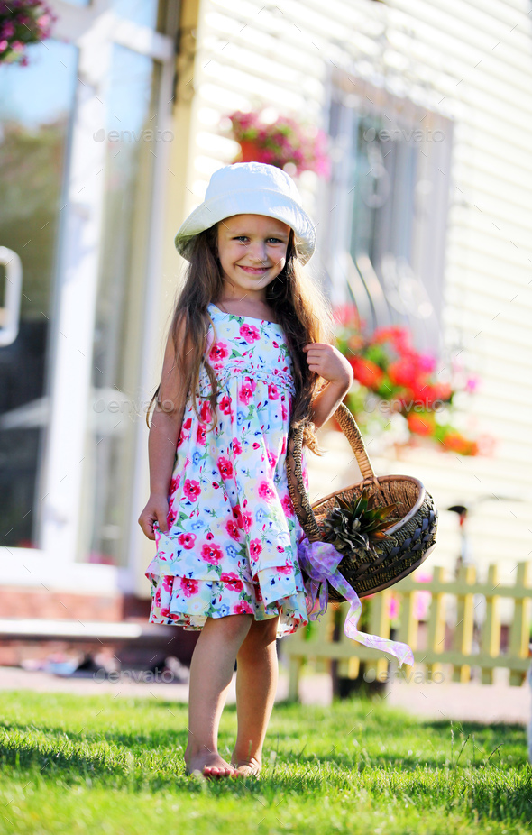 Cute four-year girl looking at camera outdoors Stock Photo by photobac
