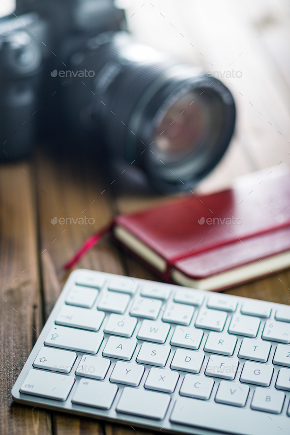 Professional digital camera and computer keyboard. Stock Photo by jirkaejc