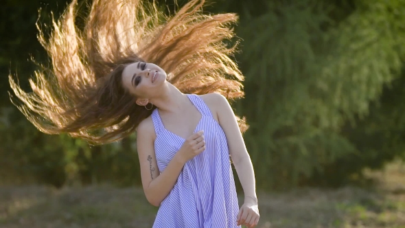 Young Stylish Girl with Makeup Shaking Head and Waving Long Hair on ...