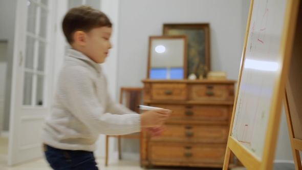 The Little Boy in the Living Room of the House Draw on the Board with ...