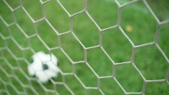 View of Soccer Ball Through Goal Net on Green Grass Field, Stock Footage
