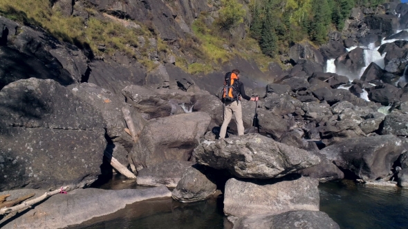 Aerial View of Man Standing in Front of a Waterfall River with Rocks ...
