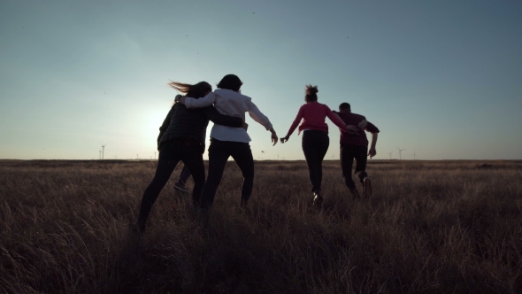 Friends Running Towards Wind Farm at Sunset, Stock Footage | VideoHive