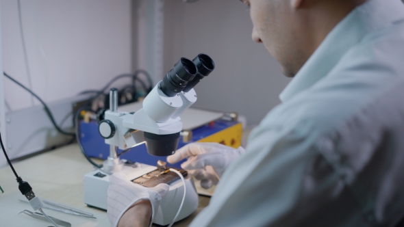 Electronic Engineer Is Examining Mobile Phone Under a Microscope ...