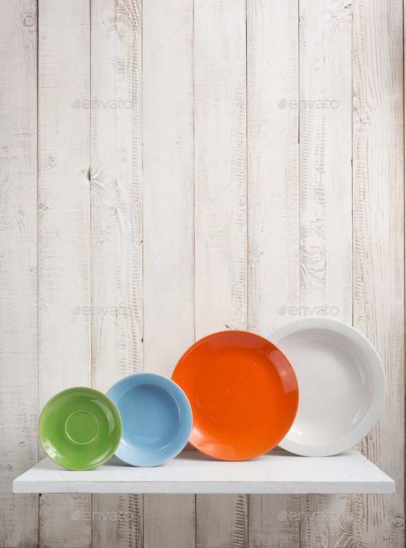 plate at kitchen shelf on wooden background Stock Photo by seregam