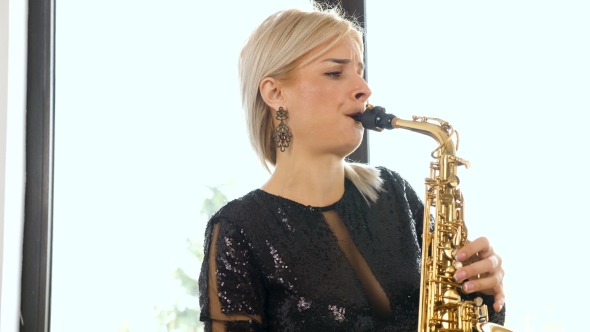 Beautiful Saxophonist Woman Playing at the Sax in the Living Room ...
