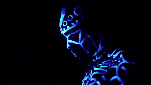 A Black Man in Neon Patterns Under Ultraviolet Light Turns and Looks ...