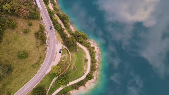 Aerial "bird eye" view of Ledro lake with a street and car and truck ...