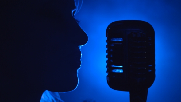 Singer Sings in a Retro Microphone. Smoke Background. Silhouette. Side ...