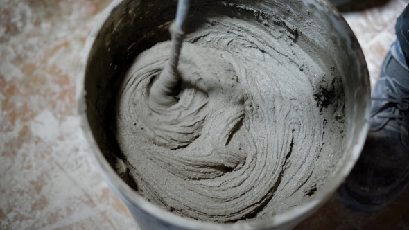 Shot of a Bucket of Cement, the Worker Mixes Loose Materials and Water ...