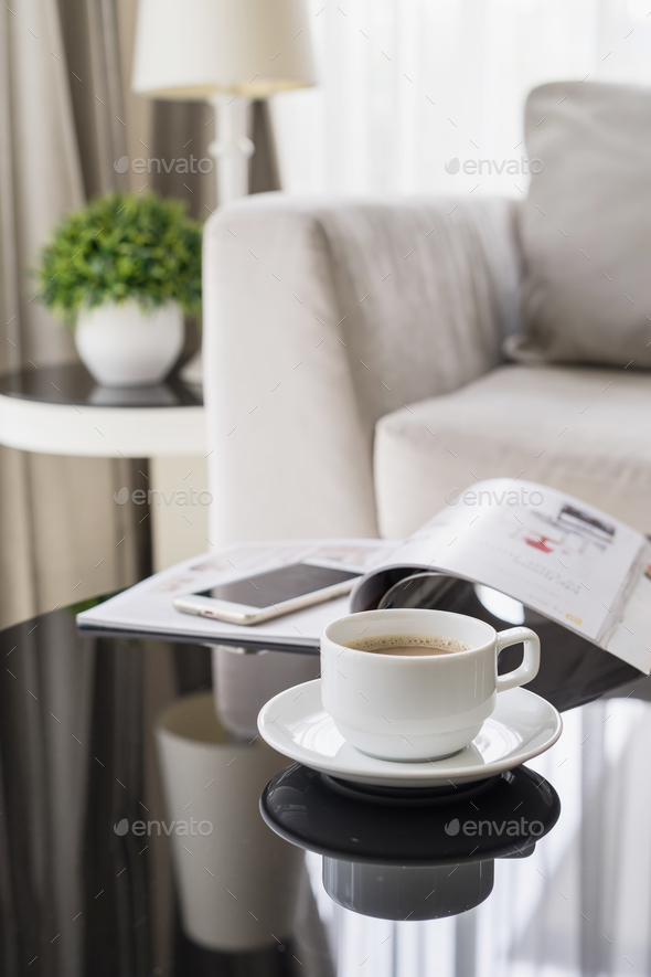 Cup of coffee on a round table with sofa in living room Stock Photo by ...