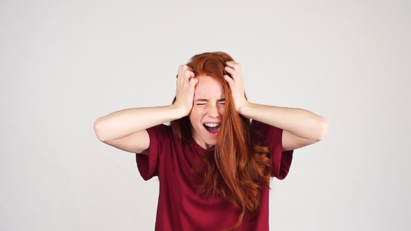 Screaming Redhead Girl in Sweater Covering Her Ears with Closed Eyes ...
