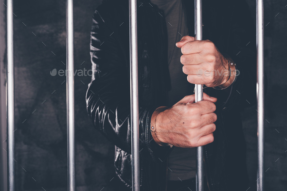 Handcuffed man behind prison bars Stock Photo by stevanovicigor | PhotoDune