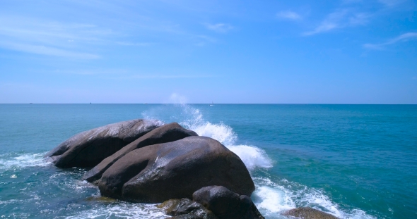 Aerial: The Waves Are Washed Up and Bumped Up a Large Rock in the Sea ...