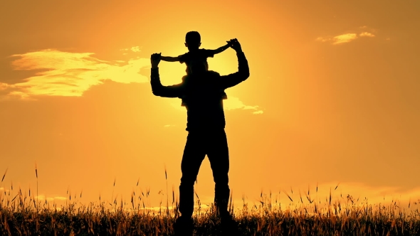 Silhouette of a Happy Father Holding His Child's Shoulders Against the Sunset, Stock Footage