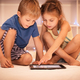 Two happy children playing on the tablet Stock Photo by Anna_Om | PhotoDune