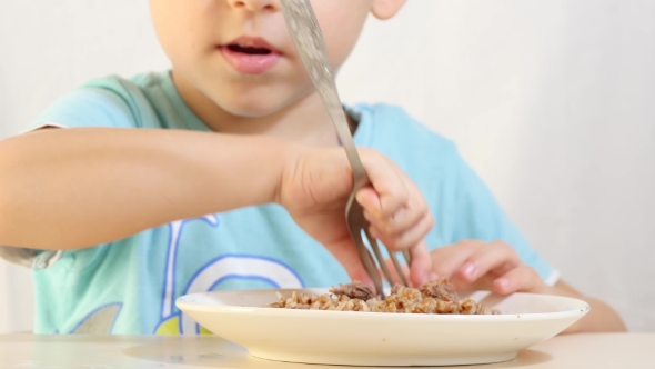 of a Child Eating Food with a Fork, Sitting at a Table, Stock Footage