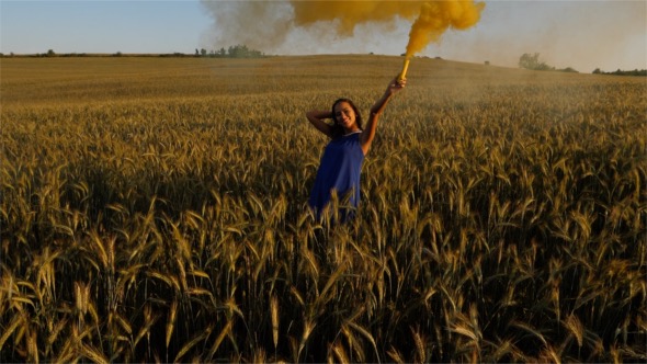 Beautiful Girl with Coloured Smoke in a Wheat Field, Stock Footage