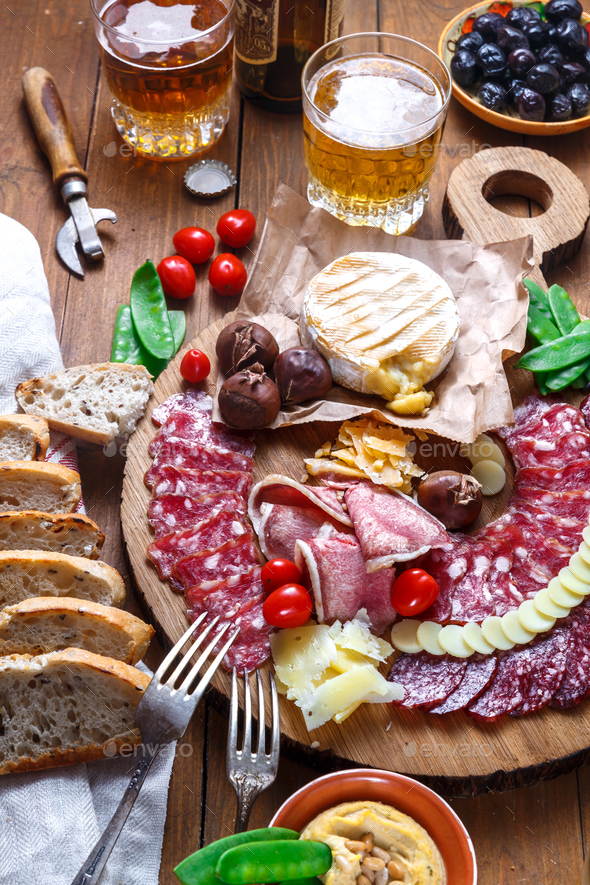 Close view of mix of delicious meat snacks on wooden board. Stock Photo ...