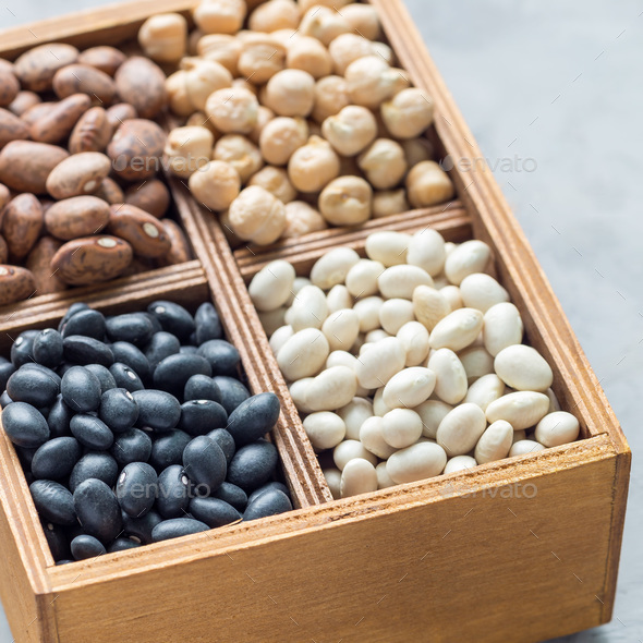 Different kinds of beans in a wooden box on concrete background, square ...