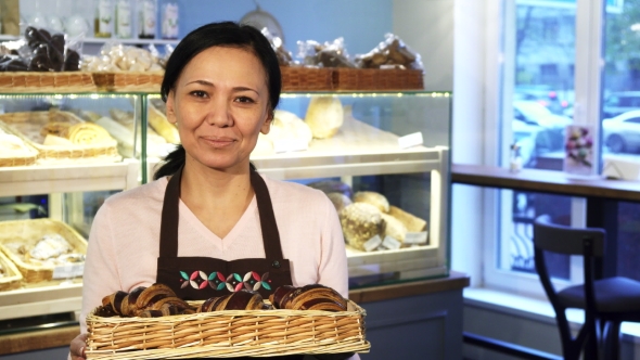 Mature Female Baker Posing at Her Store with a Basket Full of ...