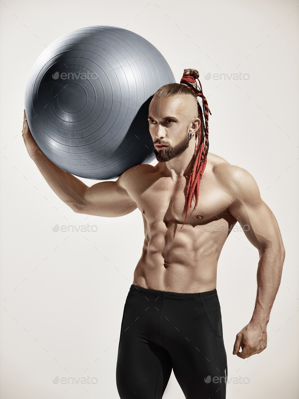 Muscular man holding fitness ball, standing isolated on white Stock ...