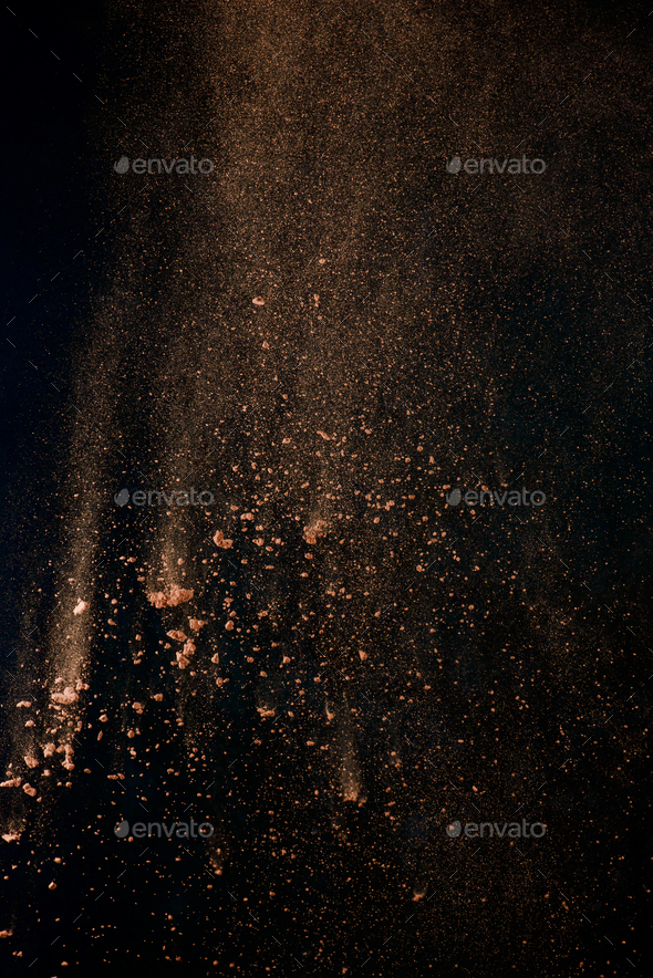 Cocoa powder explosion in motion. Chocolate dust on a black background ...